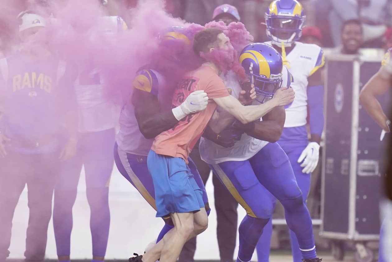 Protester flattened by player while running on NFL field files police ...