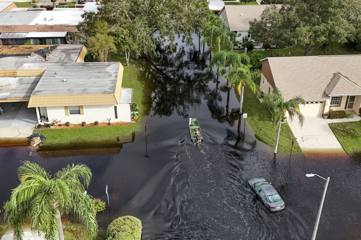 Residents slog through flooded streets, clear debris after Hurricane ...